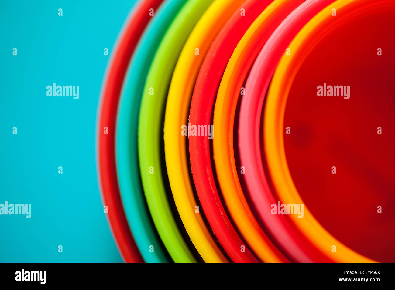 Child's toy stacking cups. Rainbow coloured cups sat on a blue ...