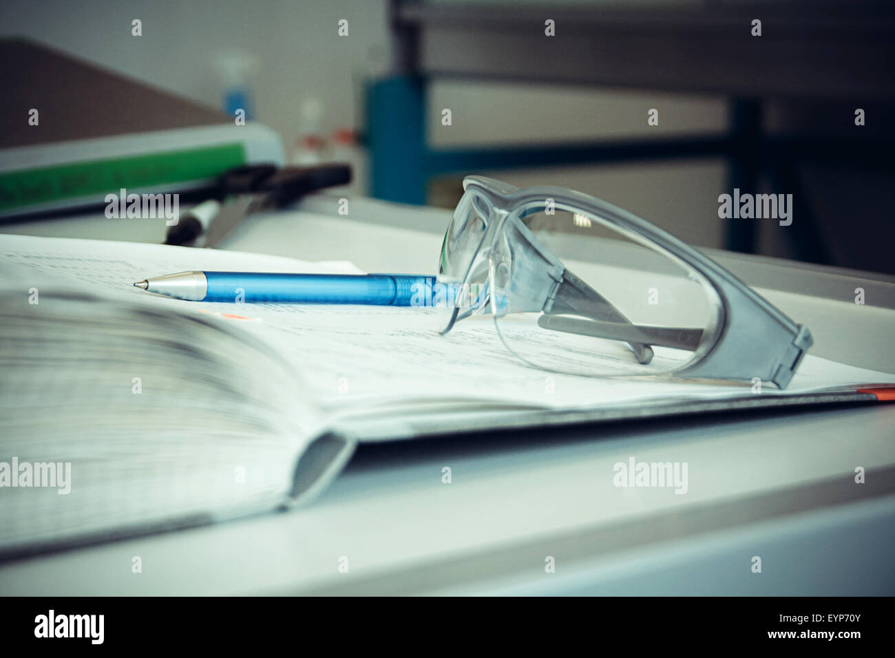 Thick Laboratory Journal with goggles, pen, soft focus Stock Photo - Alamy