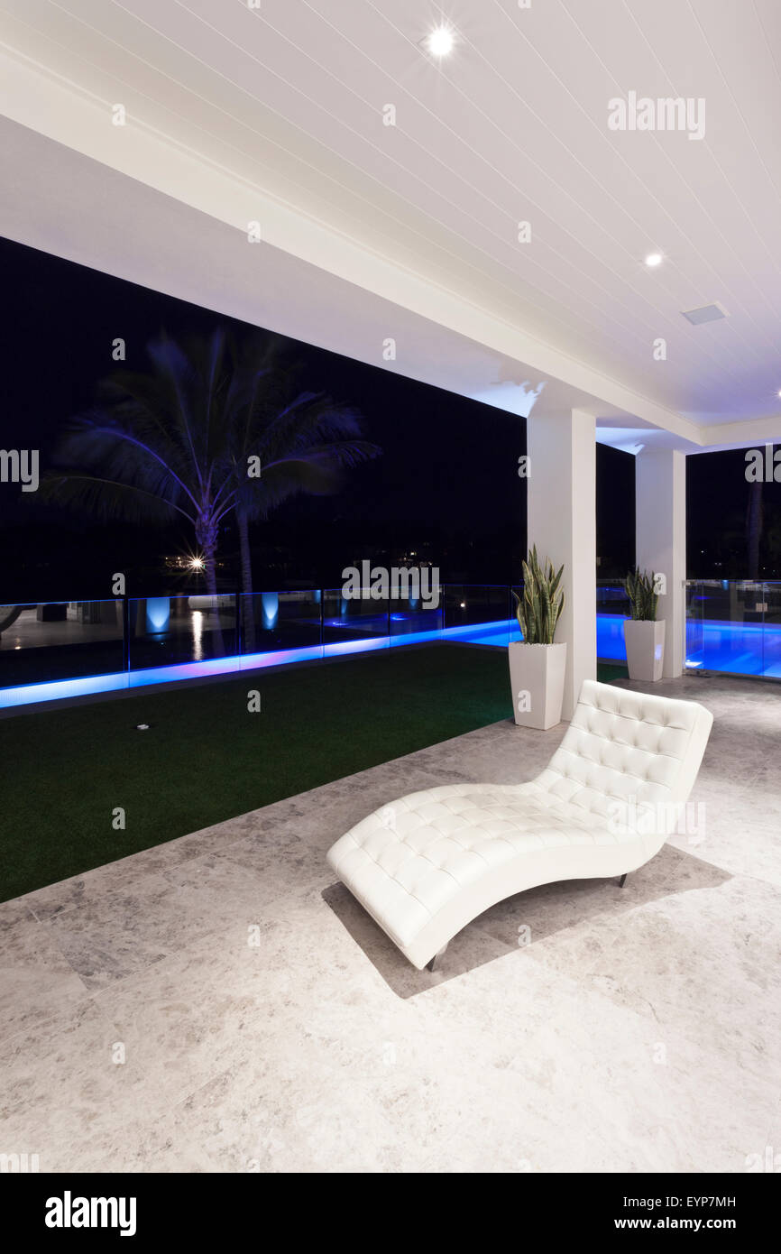 White leather beach chair in front of a luxurious pool in a villa Stock ...
