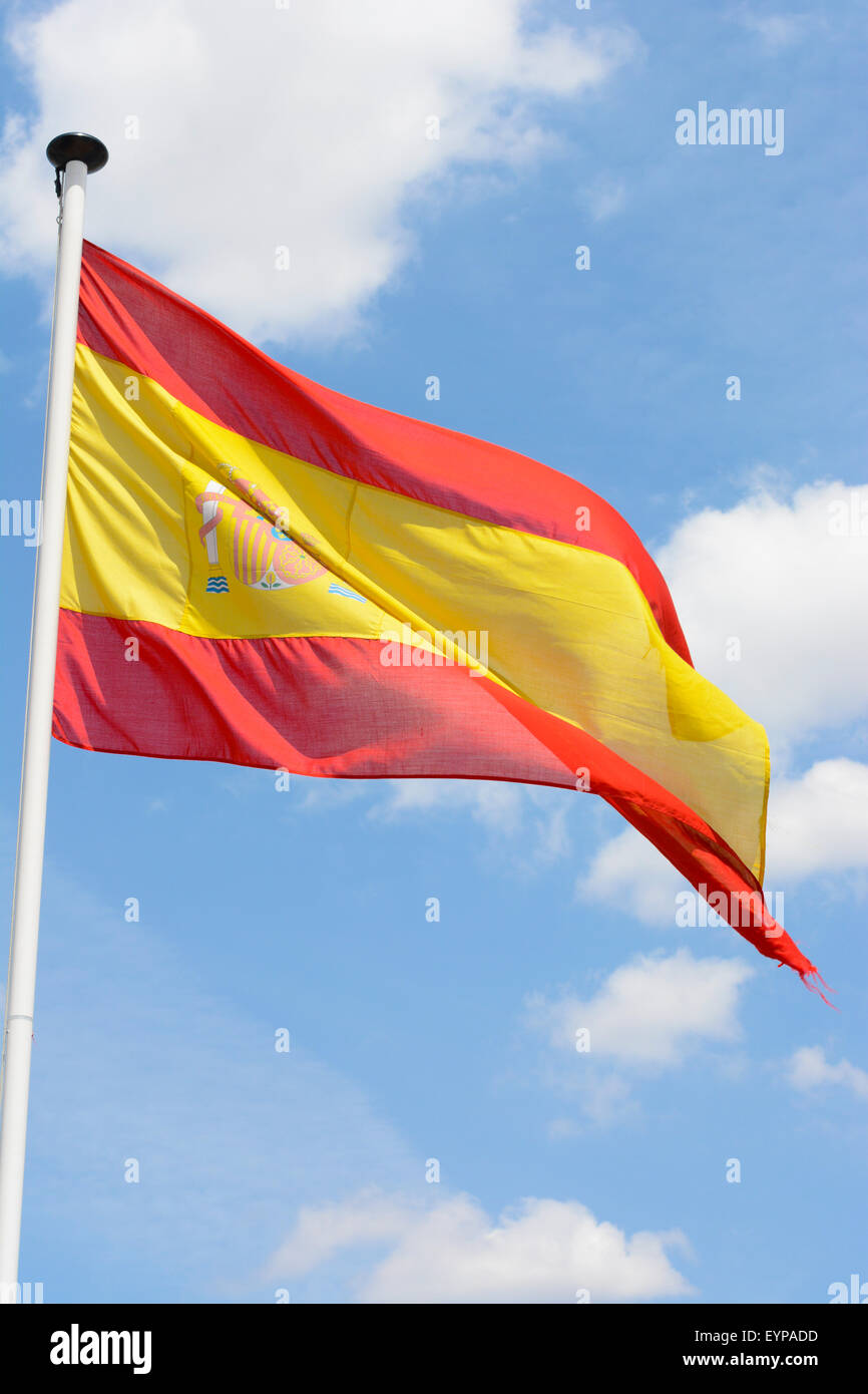 The Spanish Flag against a Blue Sky with White Clouds Stock Photo - Alamy