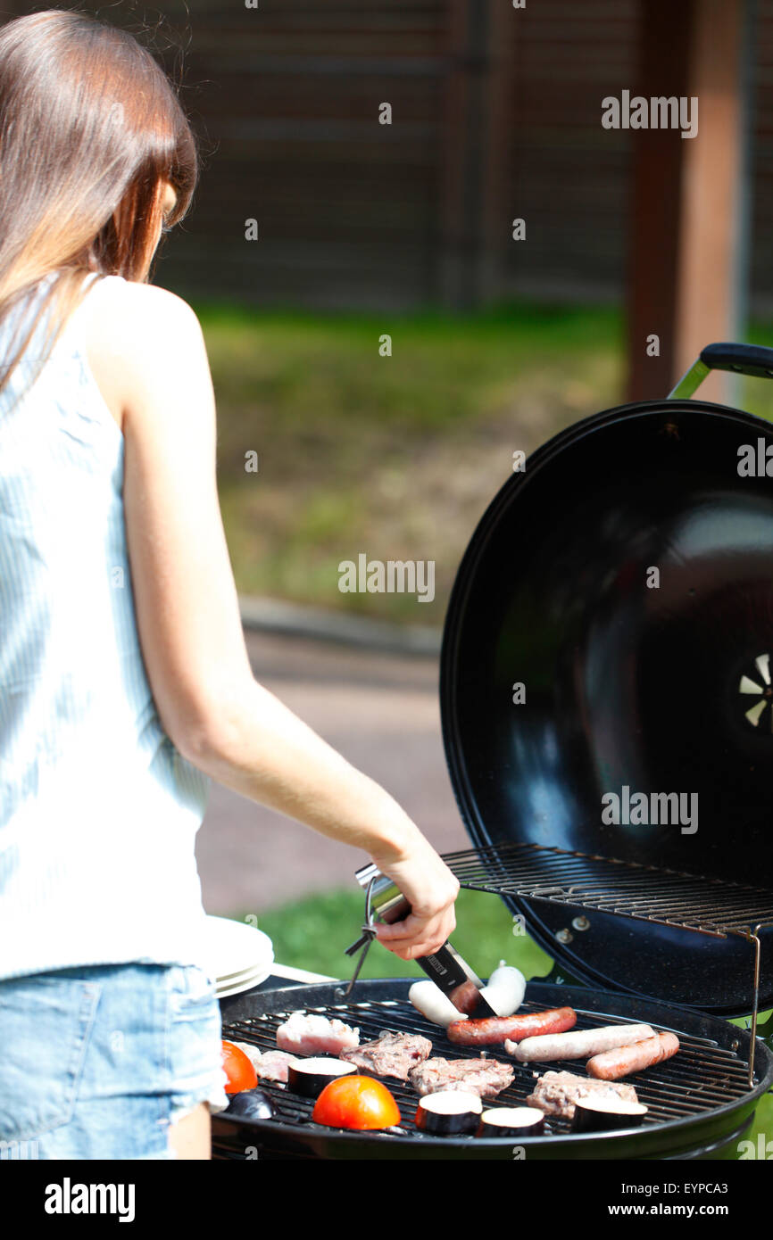 Young woman cooking on barbecue hi-res stock photography and images - Alamy