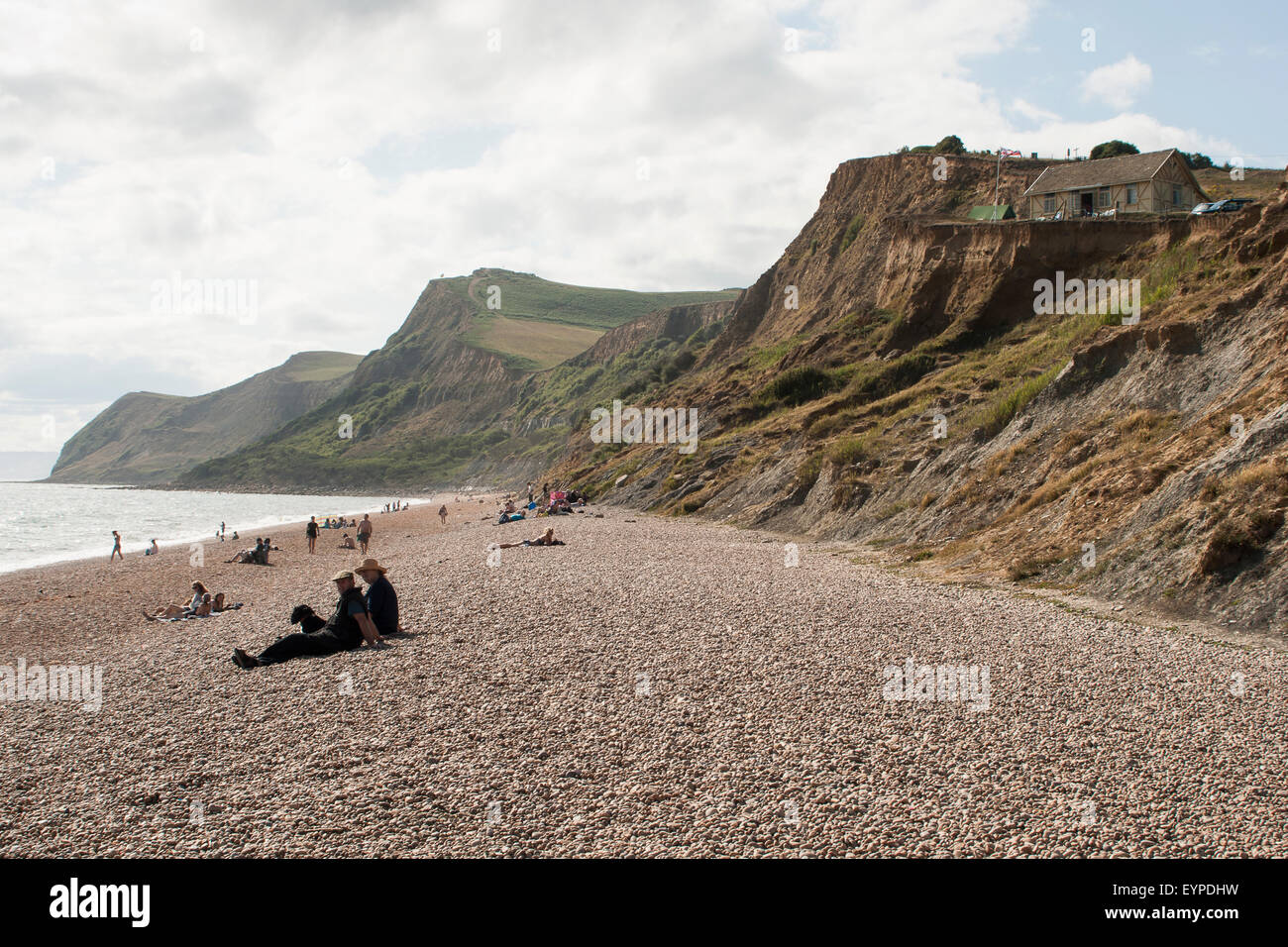 People sitting on a beach on the Jurassic coast at Eype near Bridport ...