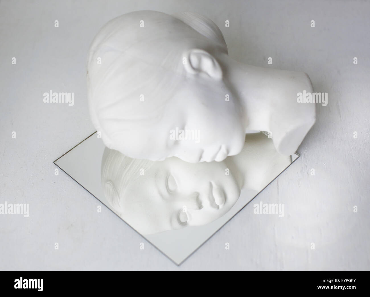 A statue of a woman lying against a mirror Stock Photo - Alamy