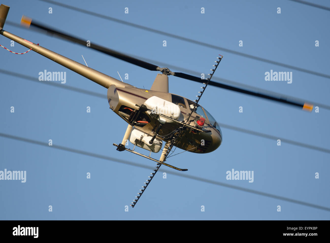 A helicopter avoids power wires while spraying a farm with fertiliser ...