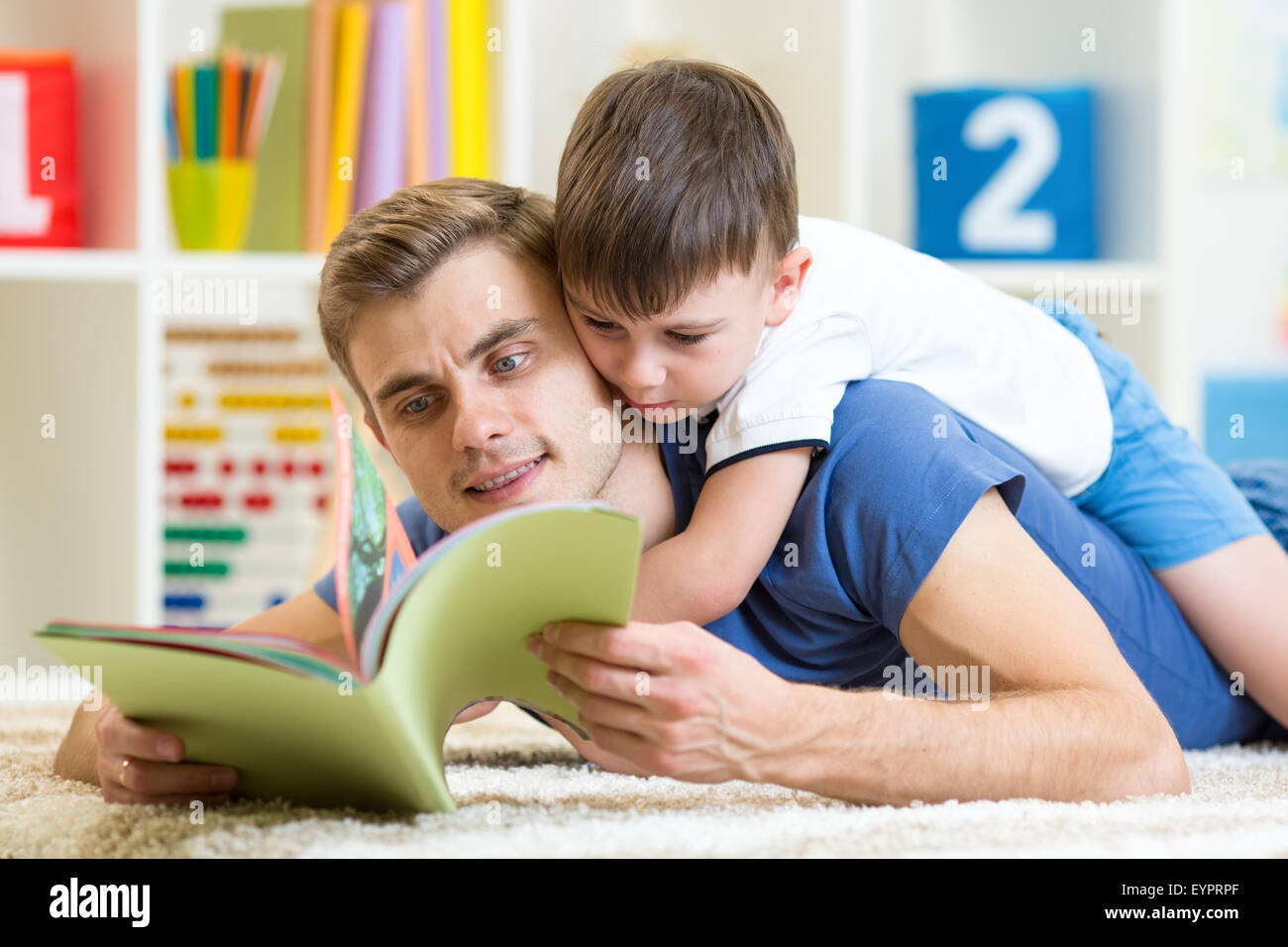father teaches reading book to kid Stock Photo - Alamy