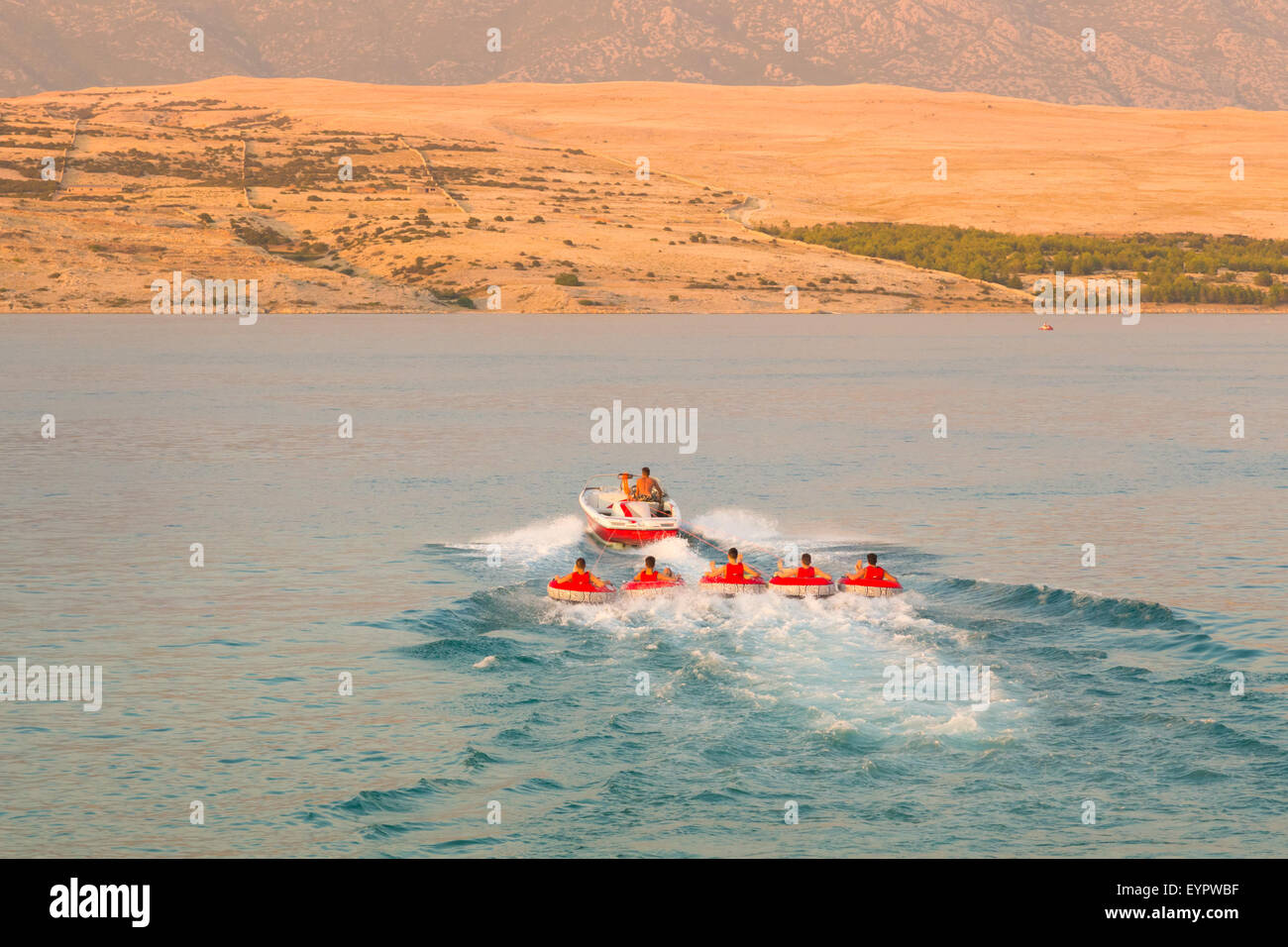 Kids tube riding tawed by speedboat Stock Photo - Alamy