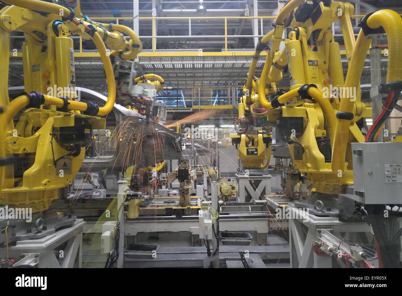 Inside a modern car factory, vehicles and parts move through the ...