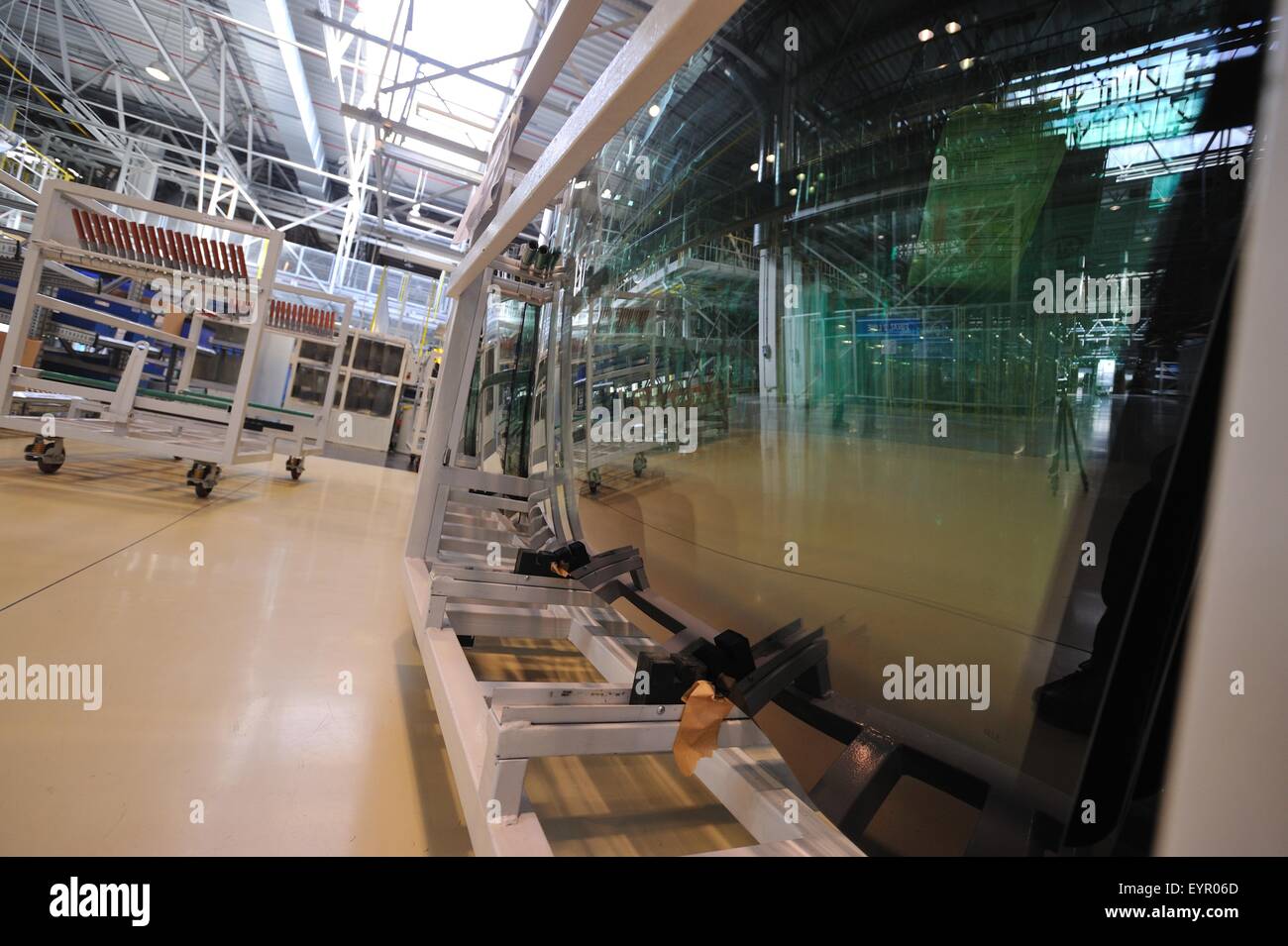 Inside a modern car factory, vehicles and parts move through the ...