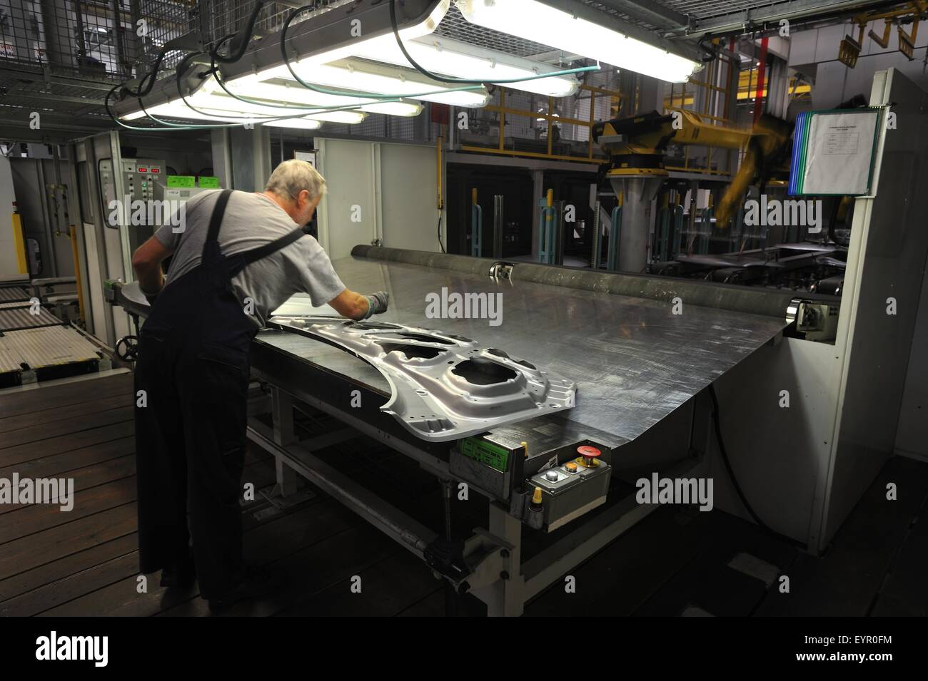 Inside a modern car factory, vehicles and parts move through the ...