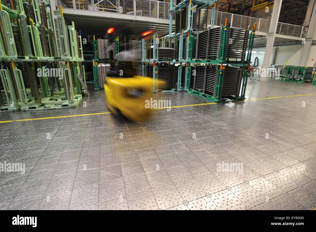 Inside a modern car factory, vehicles and parts move through the ...