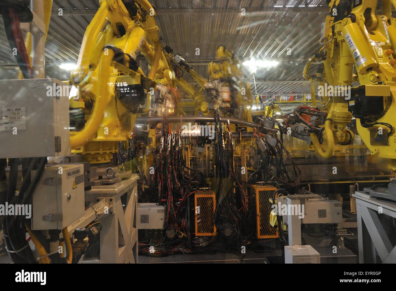 Inside a modern car factory, vehicles and parts move through the ...