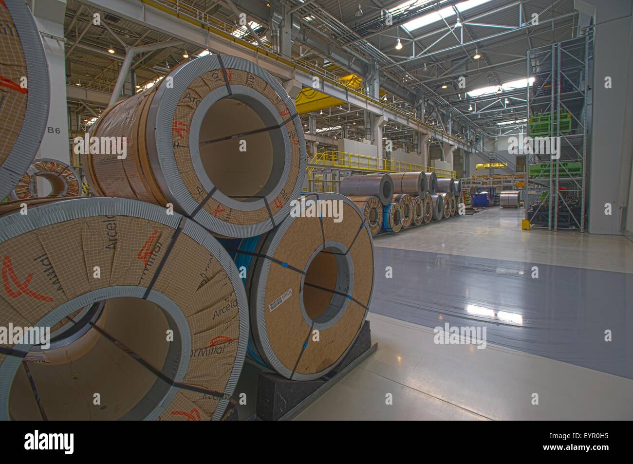 Inside a modern car factory, vehicles and parts move through the ...