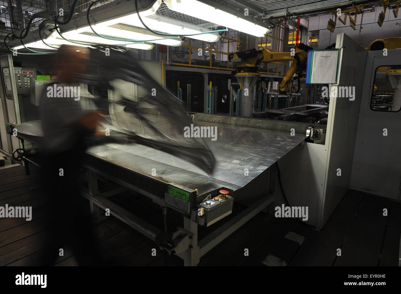 Inside a modern car factory, vehicles and parts move through the ...