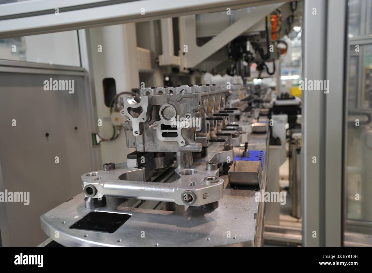 Inside a modern car factory, vehicles and parts move through the ...