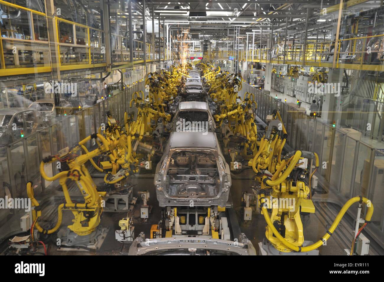 Inside a modern car factory, vehicles and parts move through the ...