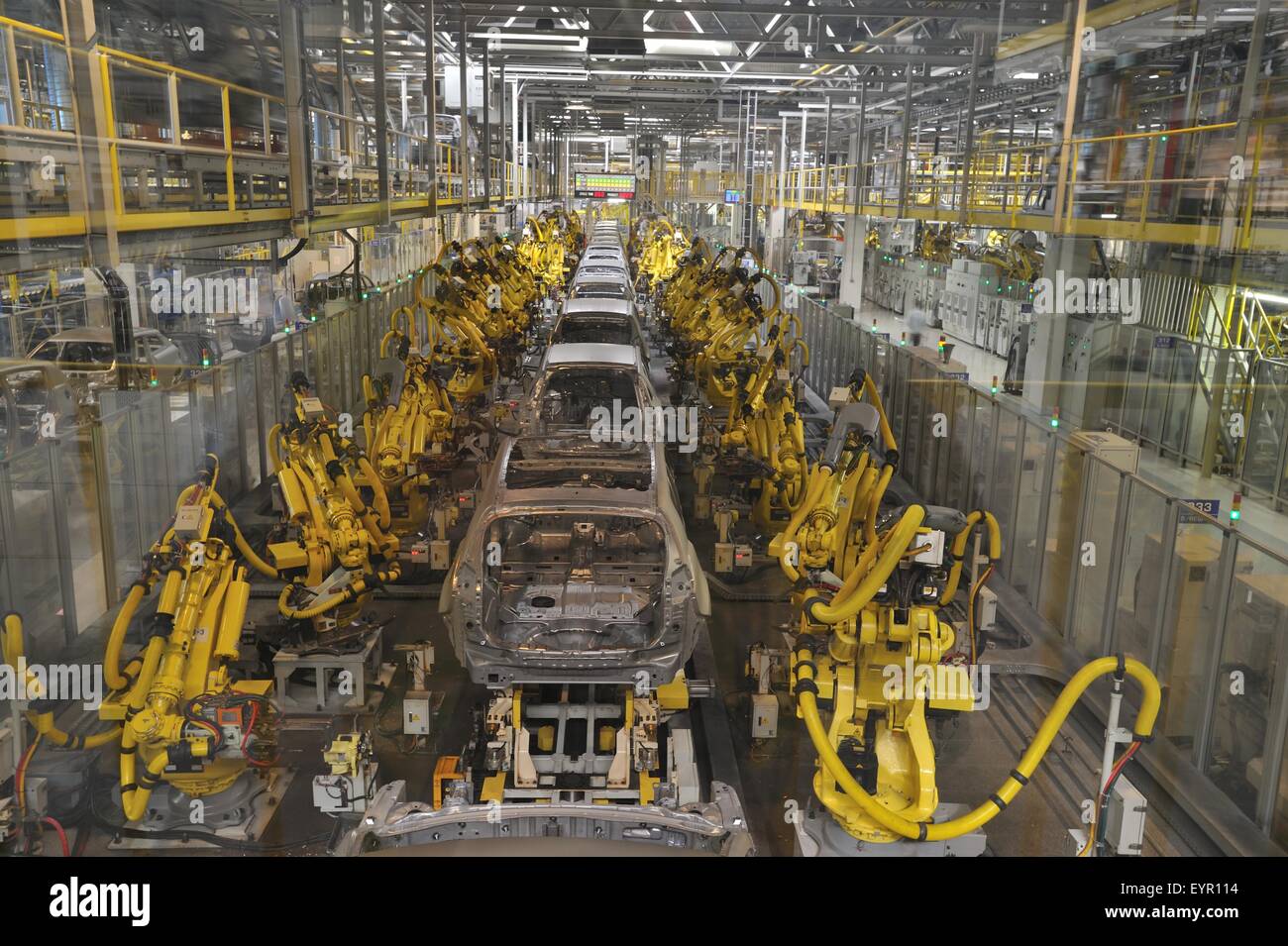 Inside a modern car factory, vehicles and parts move through the ...