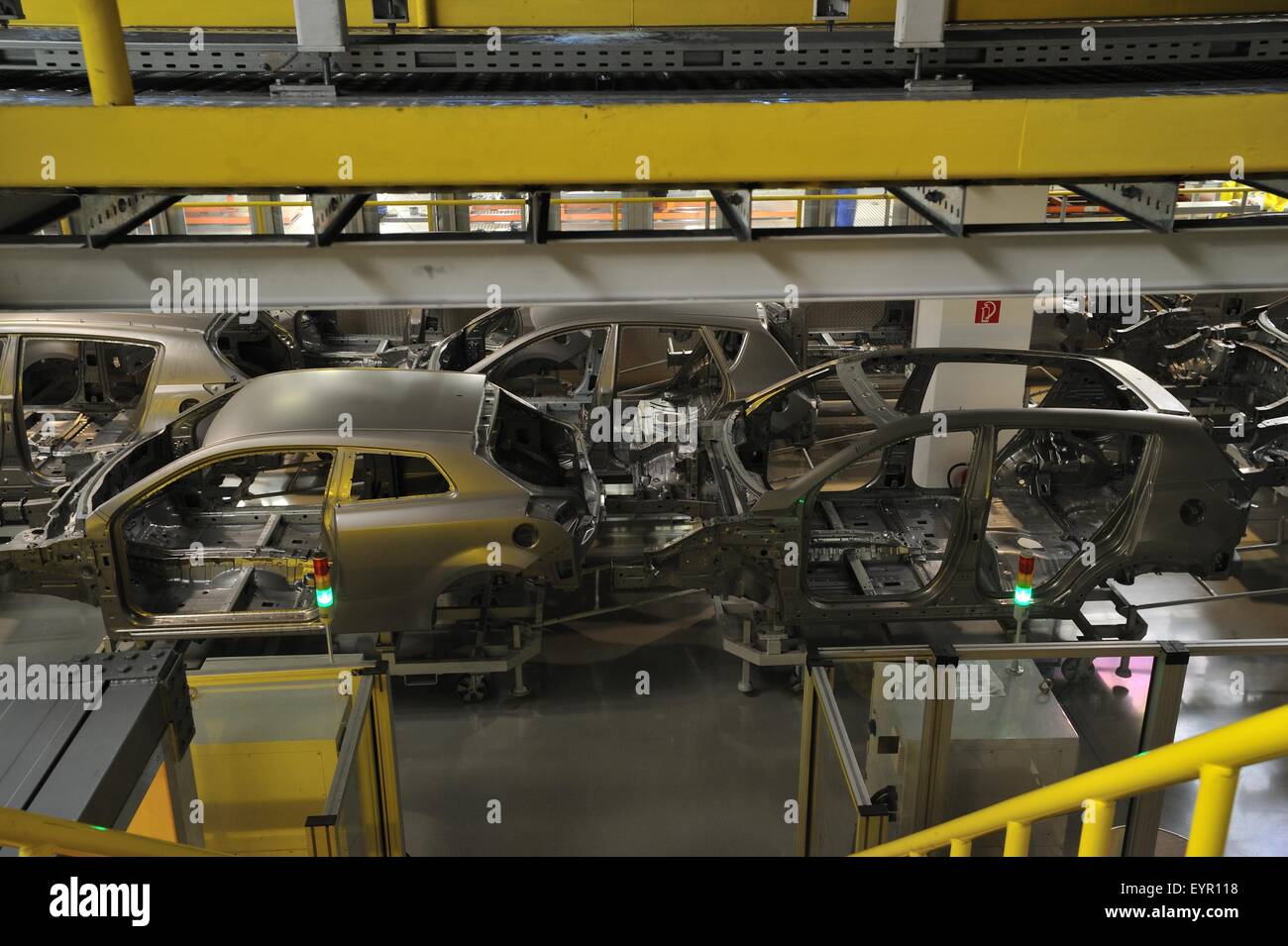 Inside a modern car factory, vehicles and parts move through the ...