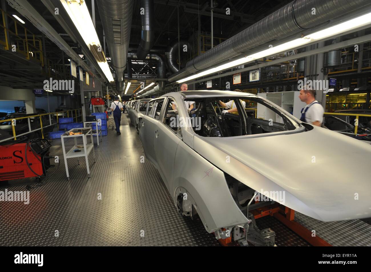 Inside a modern car factory, vehicles and parts move through the ...