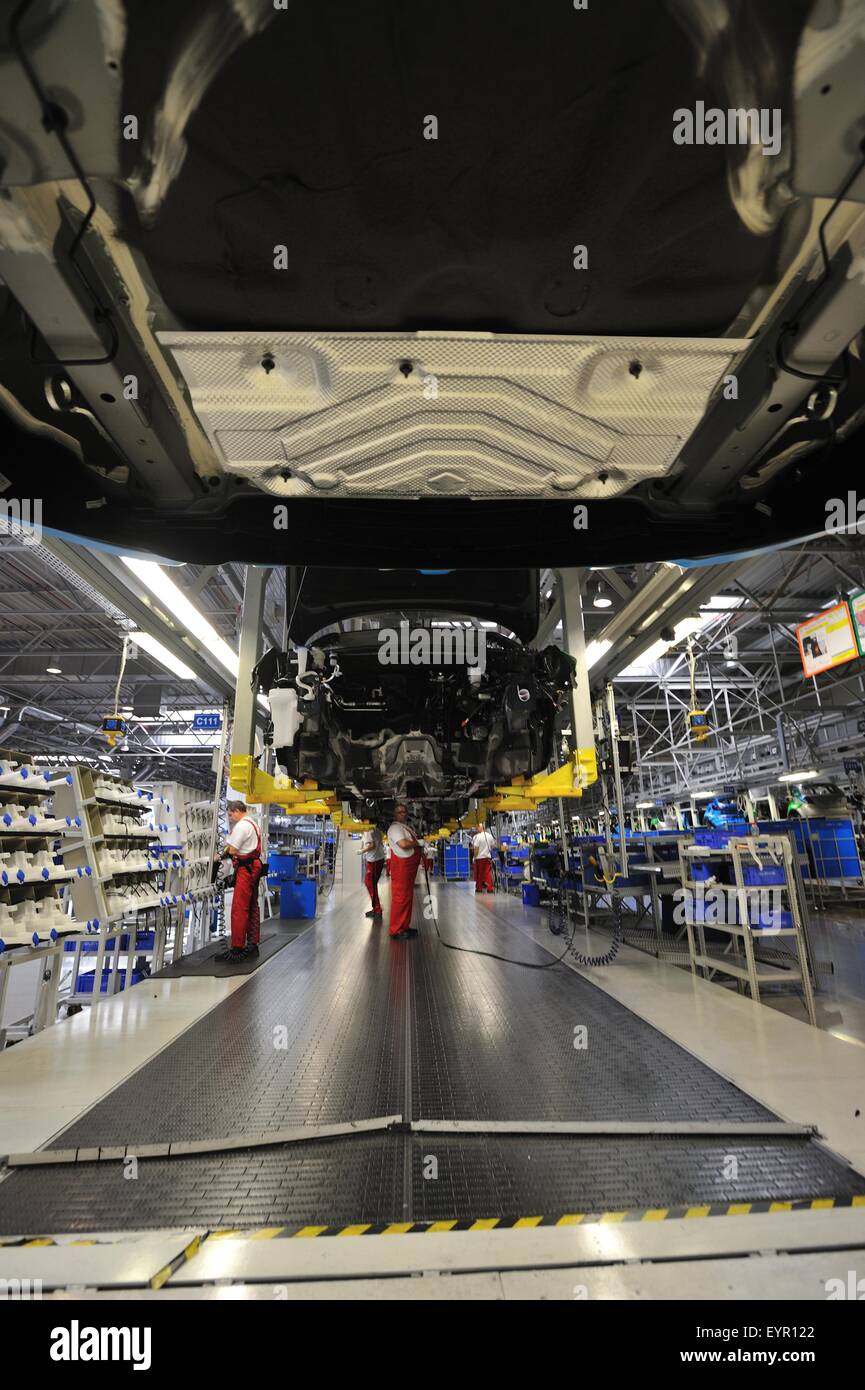 Inside a modern car factory, vehicles and parts move through the ...