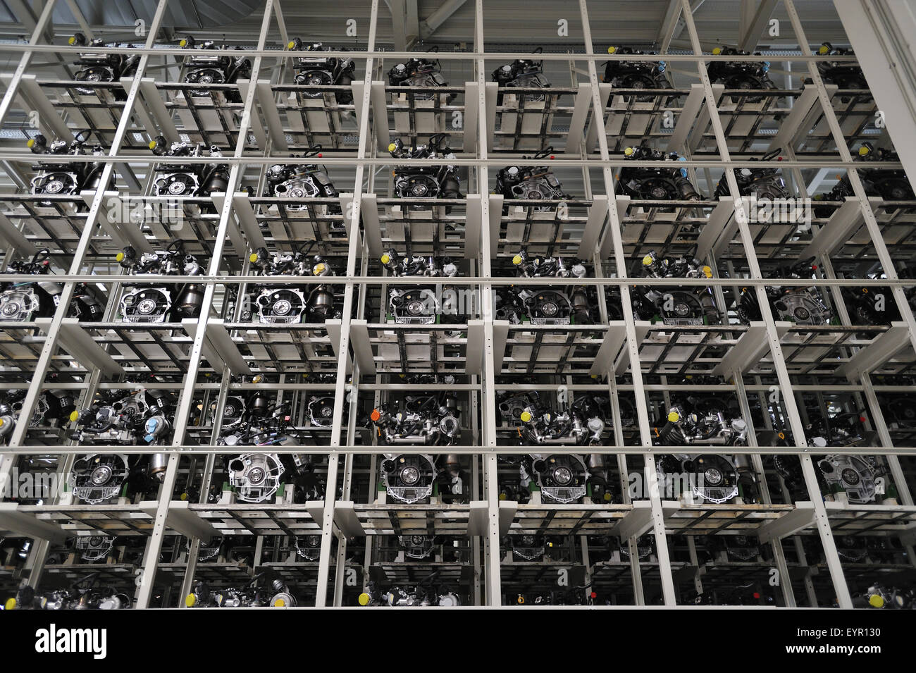Inside a modern car factory, vehicles and parts move through the ...