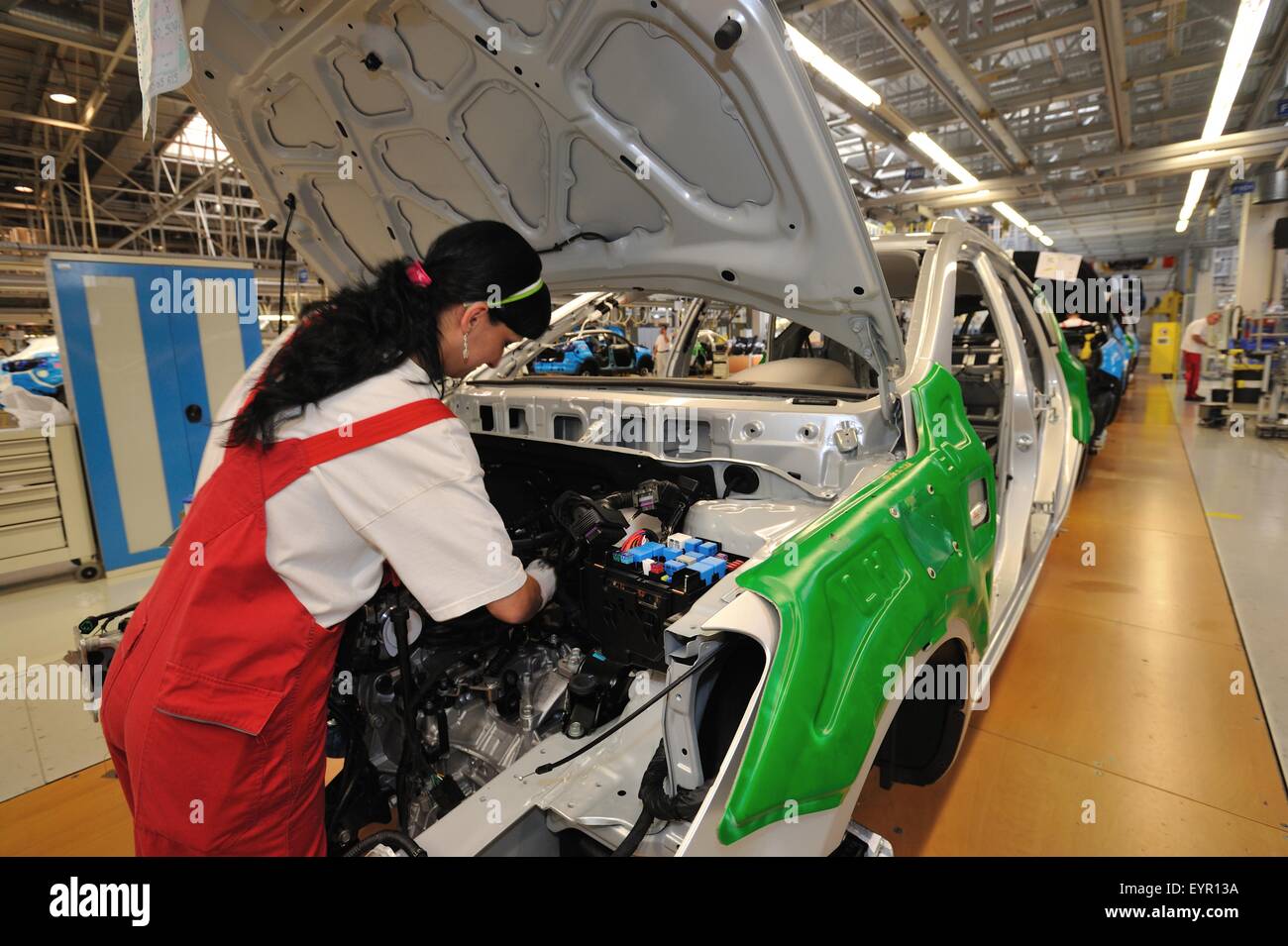 Inside a modern car factory, vehicles and parts move through the ...