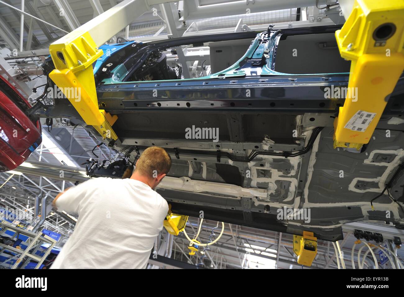 Inside a modern car factory, vehicles and parts move through the ...