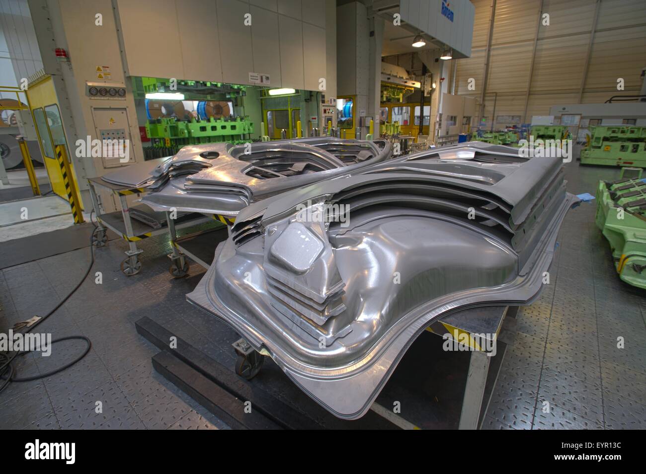 Inside a modern car factory, vehicles and parts move through the ...