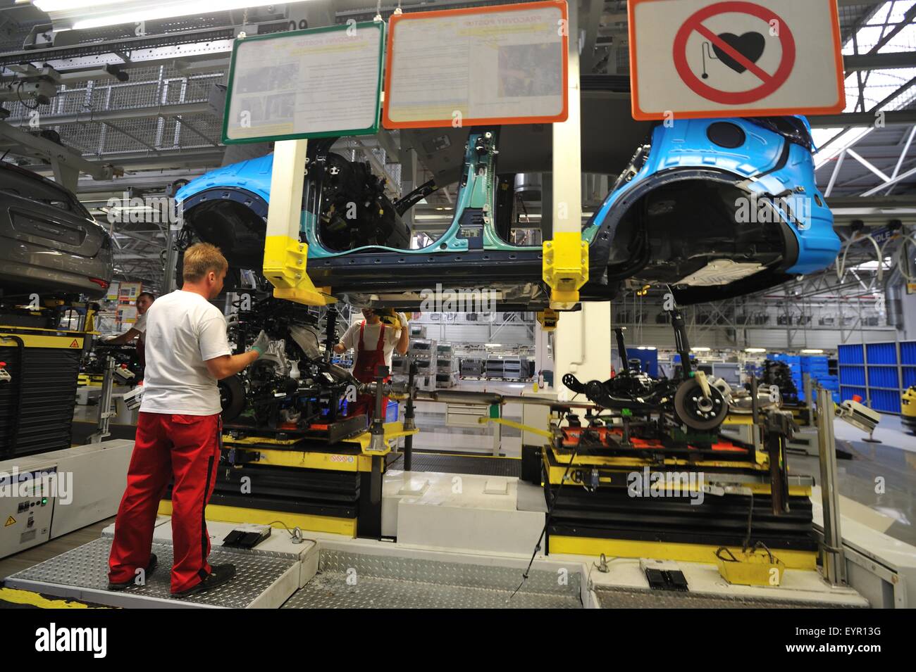 Inside a modern car factory, vehicles and parts move through the ...