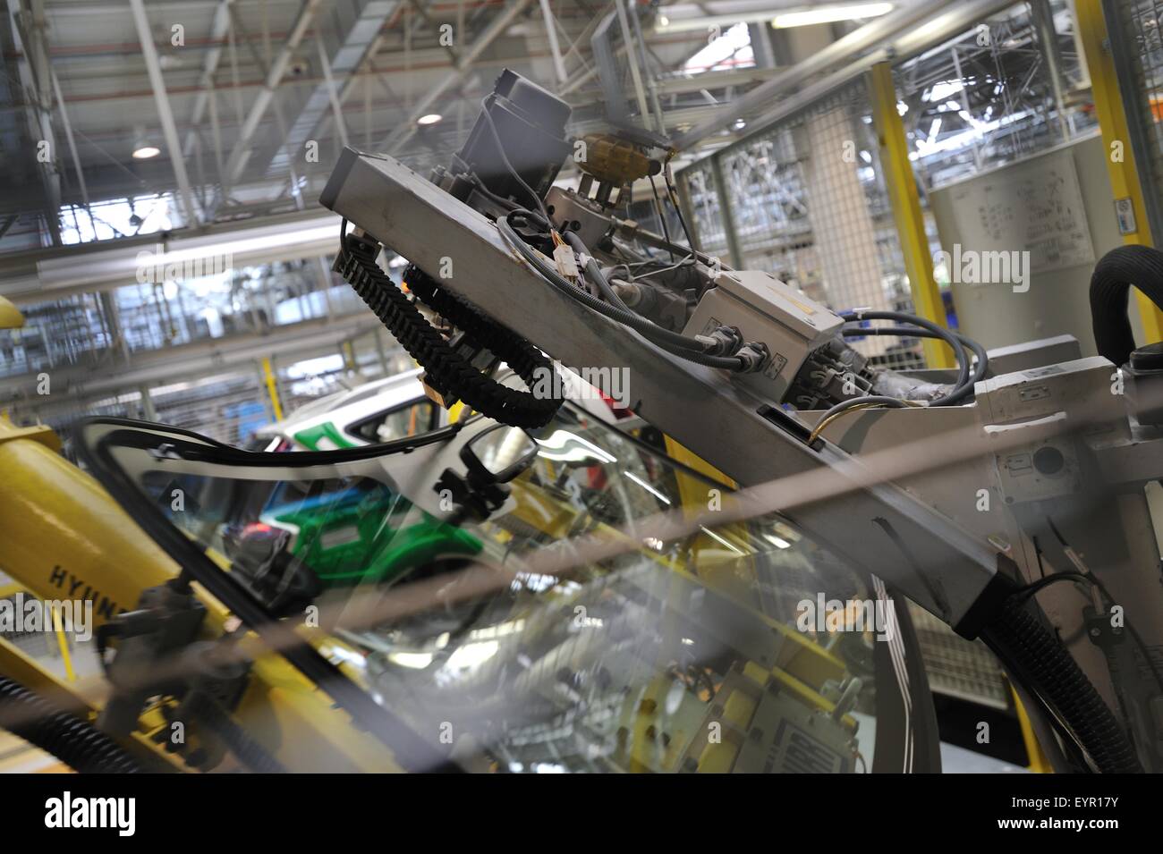 Inside a modern car factory, vehicles and parts move through the ...