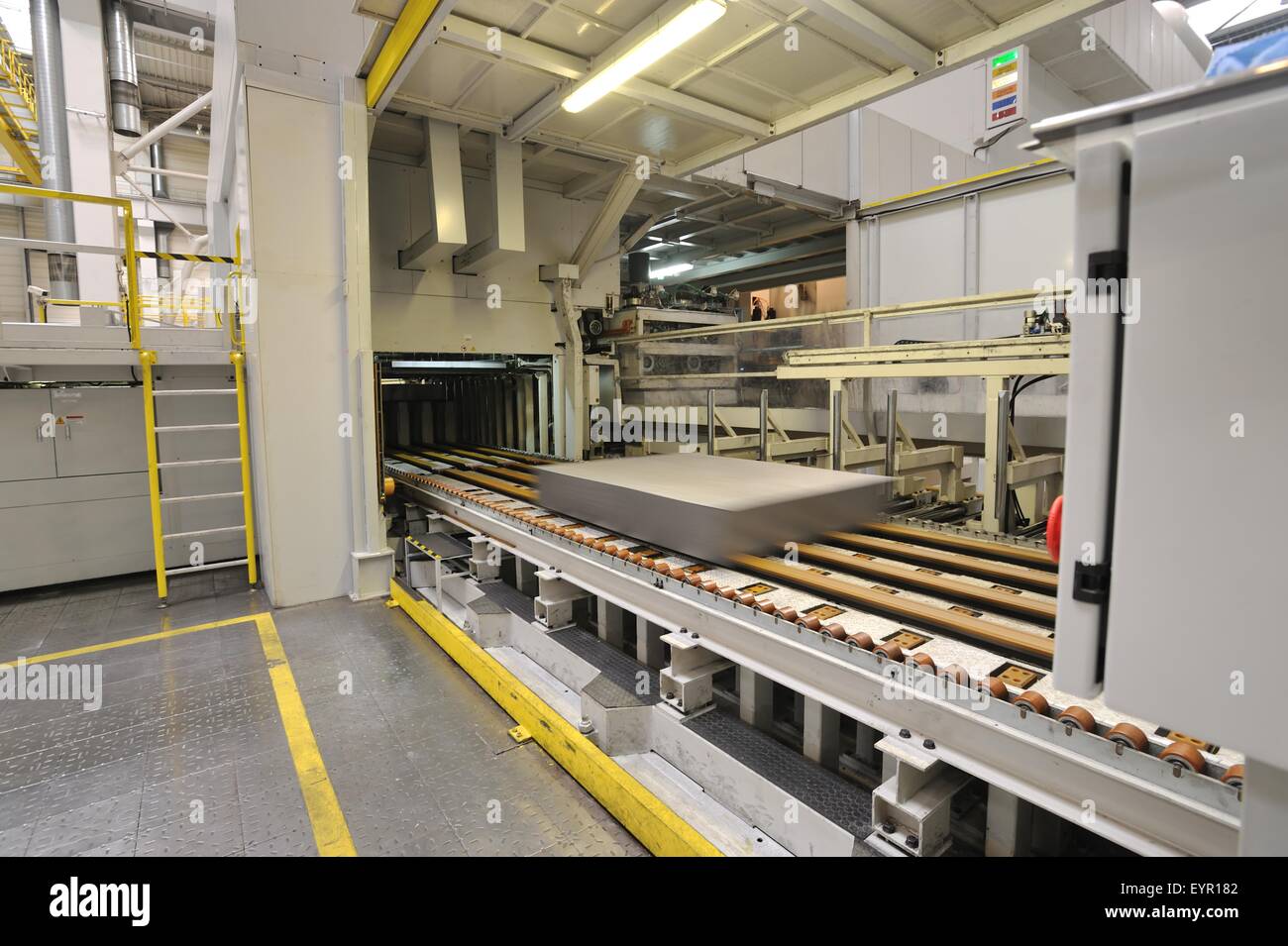 Inside a modern car factory, vehicles and parts move through the ...