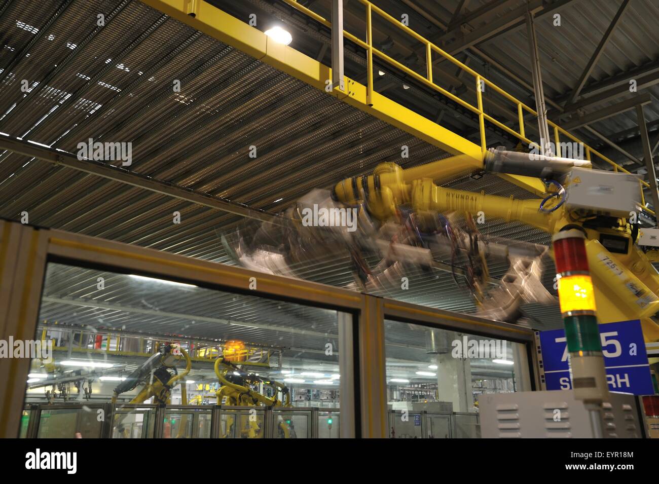 Inside a modern car factory, vehicles and parts move through the ...