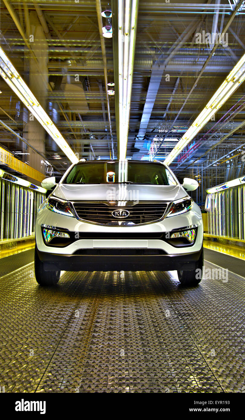 Inside a modern car factory, a brand new Kia Sportage rolls off the end ...