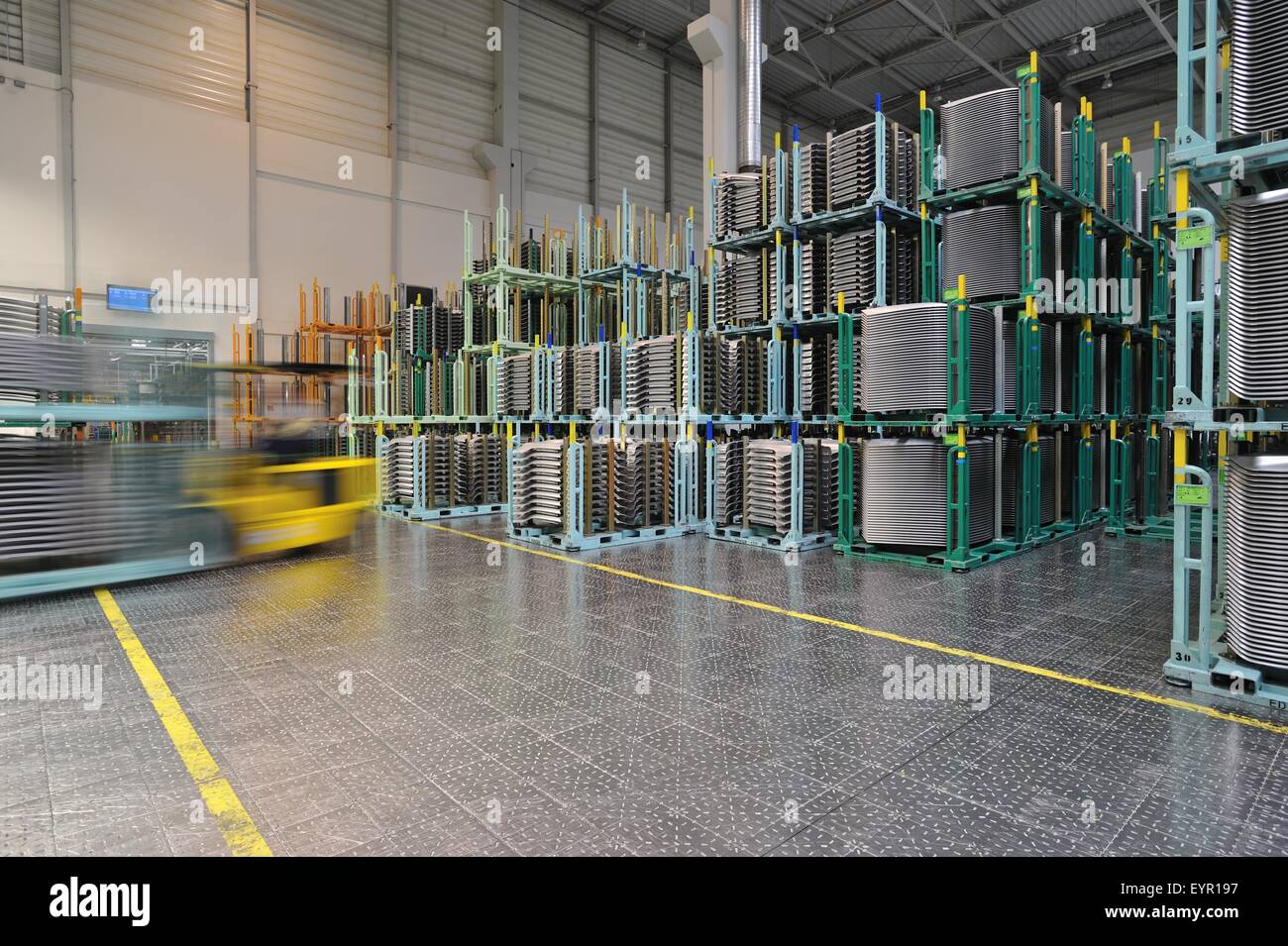 Inside a modern car factory, vehicles and parts move through the ...