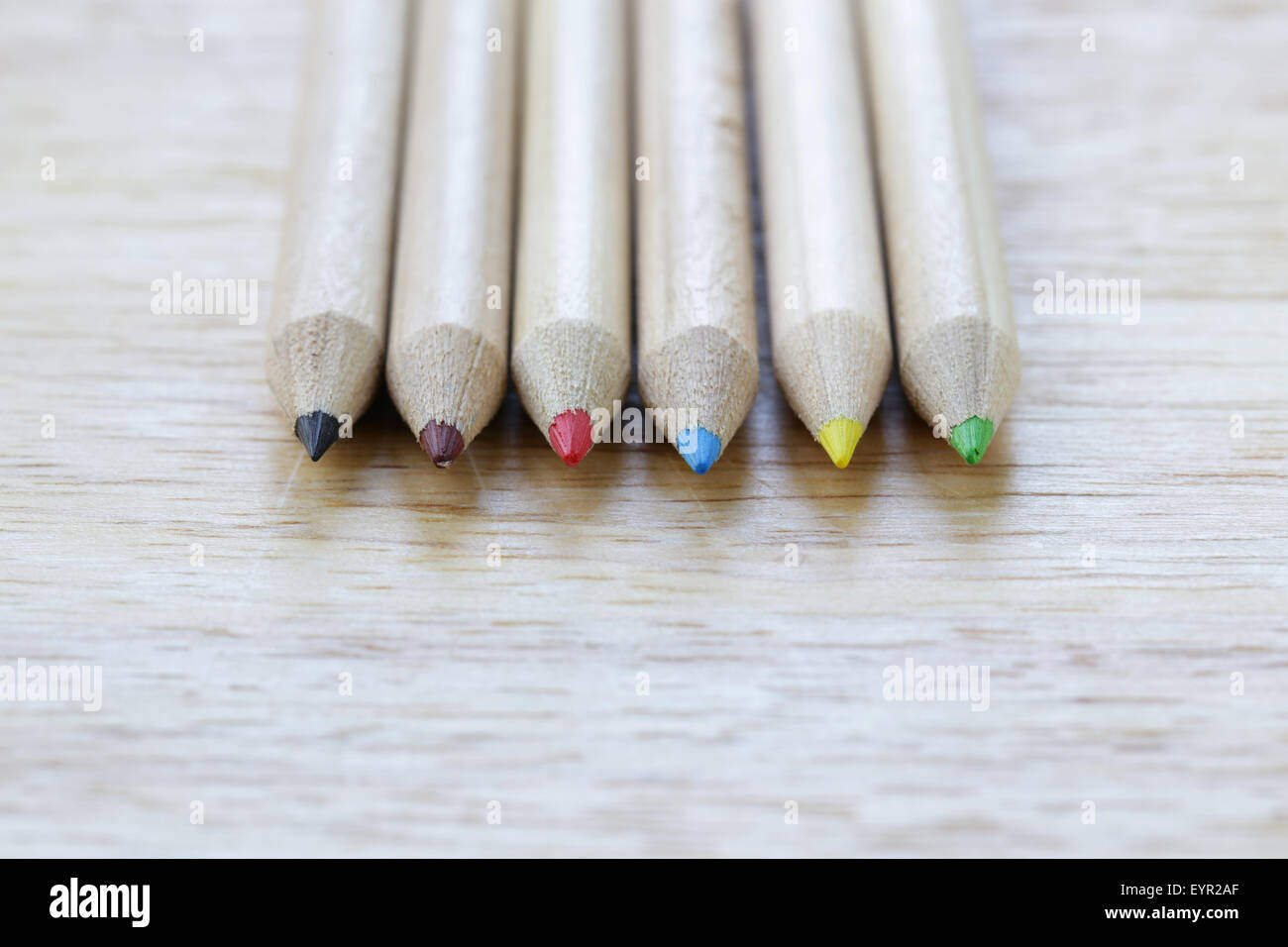 different colored wooden pencils on a wooden background Stock Photo - Alamy