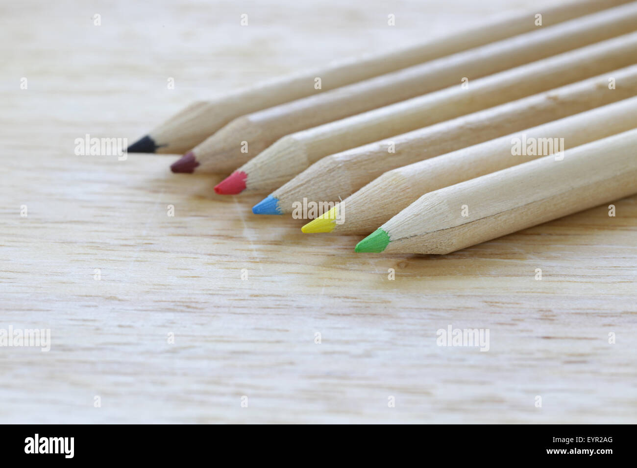 different colored wooden pencils on a wooden background Stock Photo - Alamy