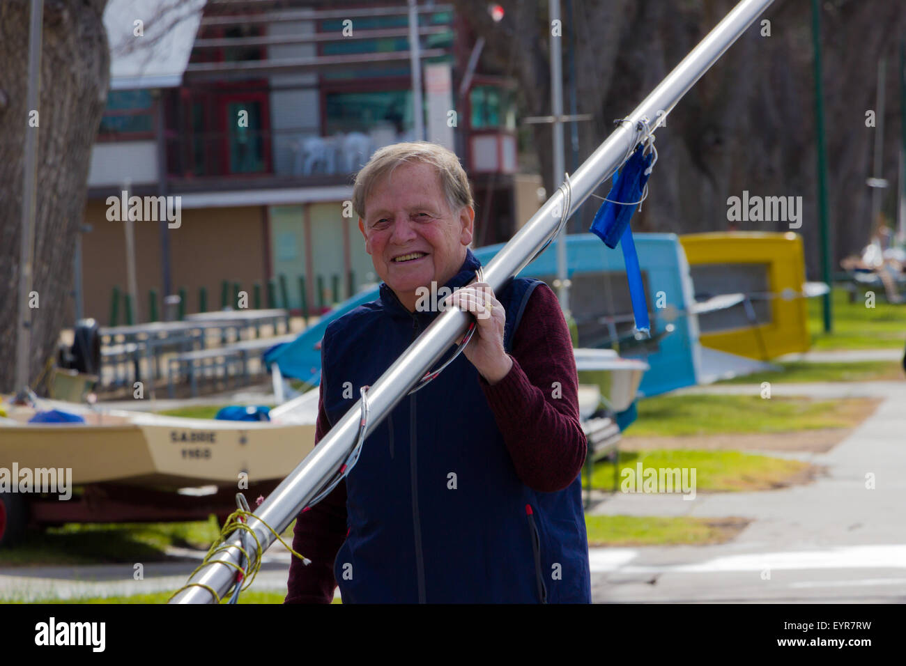 A man carrying a small mast for a small sailboat Stock Photo - Alamy