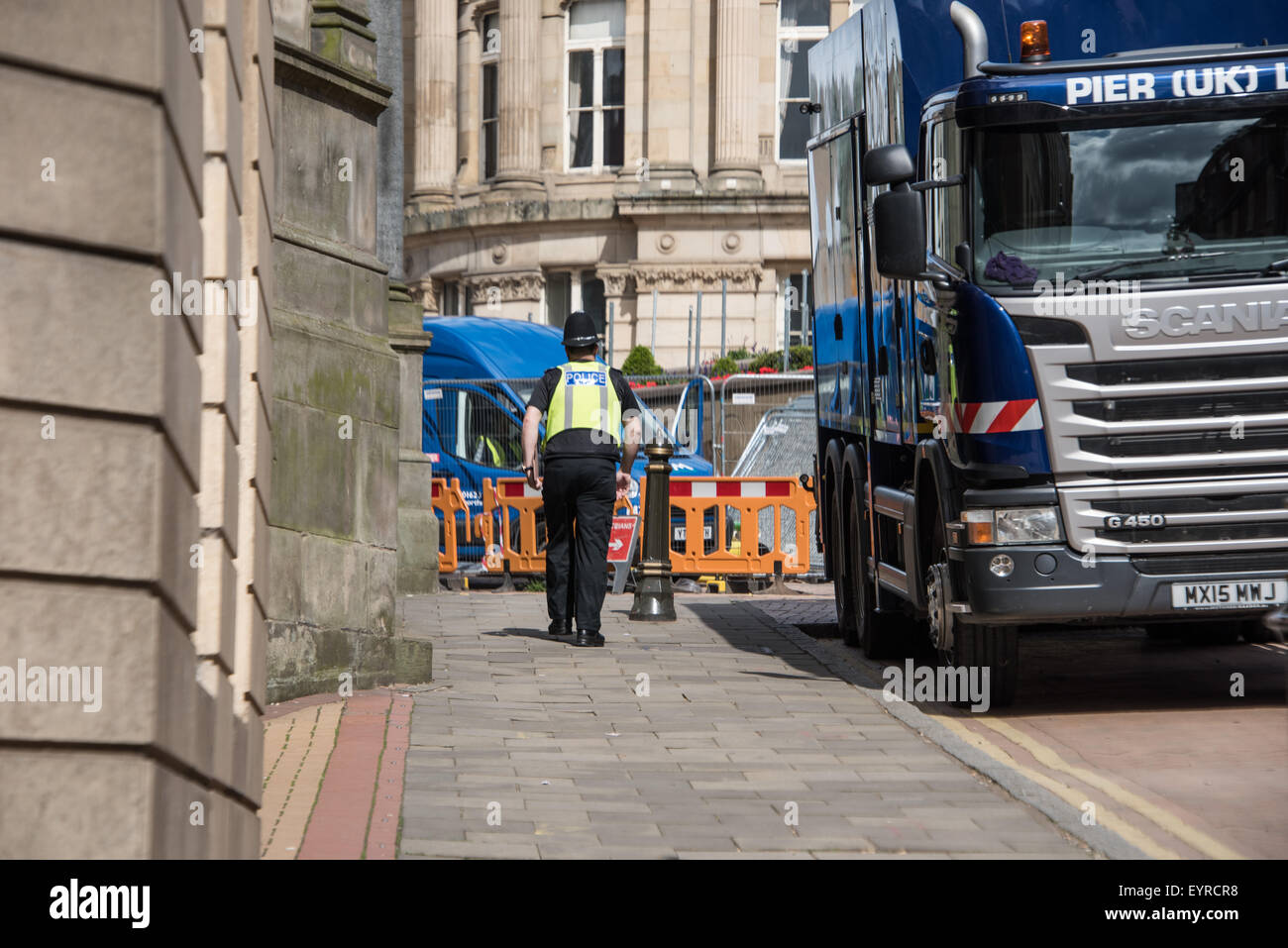 A Policeman walking down the street in Birmingham City Centre West ...