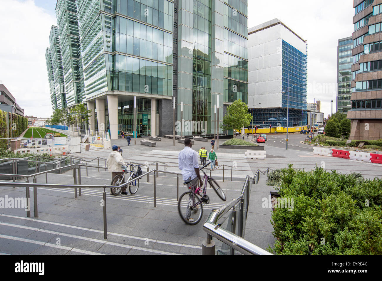 Two men carrying their bikes down steps outside office block Birmingham ...