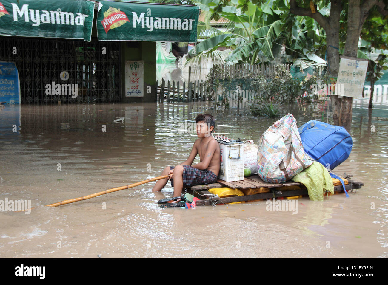Kalay, Myanmar. 3rd Aug, 2015. A boy on a makeshift raft paddles his ...