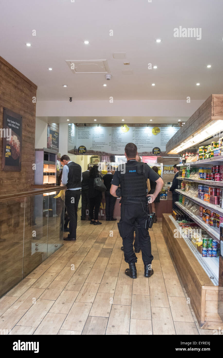 An Armed Police officer buying lunch in Birmingham city Center West ...