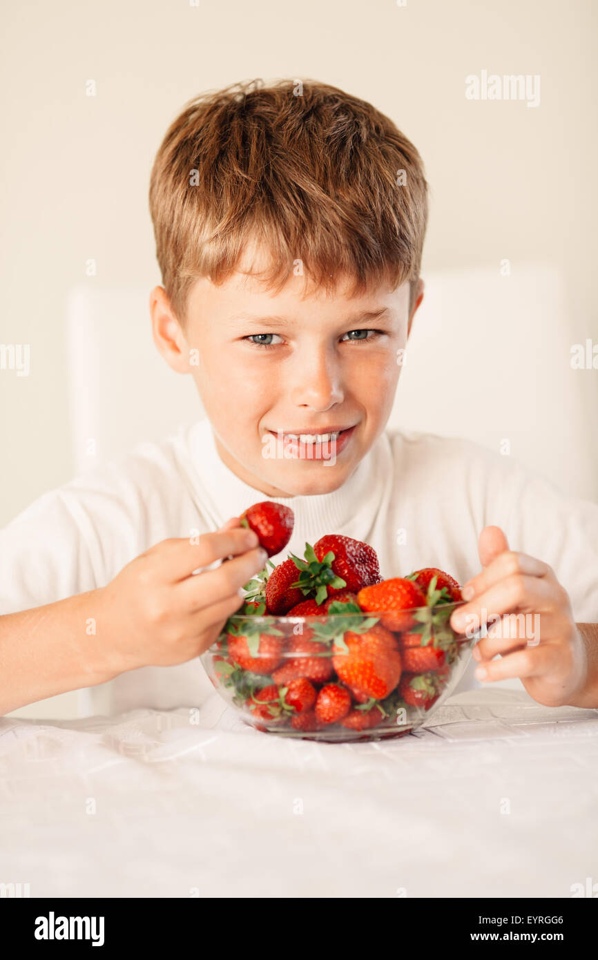 Happy little boy eating strawberries hi-res stock photography and ...