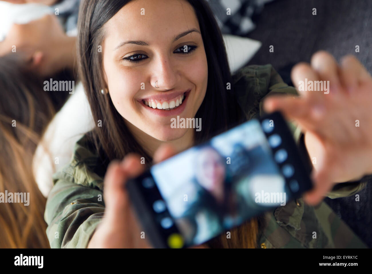 Portrait of two beautiful young woman using mobile phone at home Stock ...