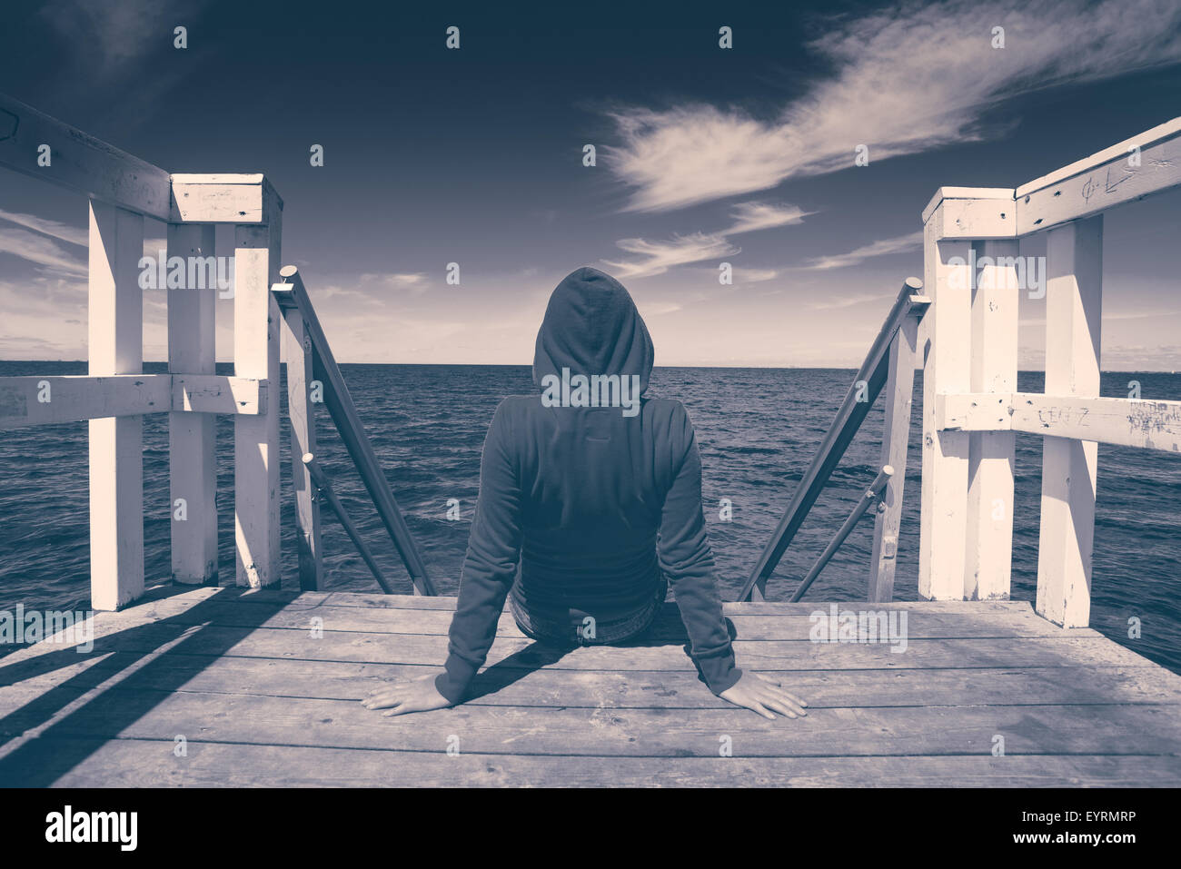 Alone Young Woman Sitting at the Edge of Wooden Pier Looking at Water ...