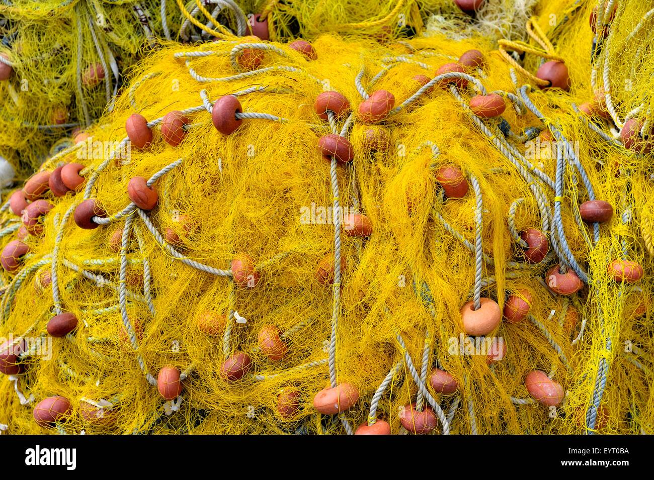 Yellow fishing nets piled up in a Greek Harbour Stock Photo - Alamy