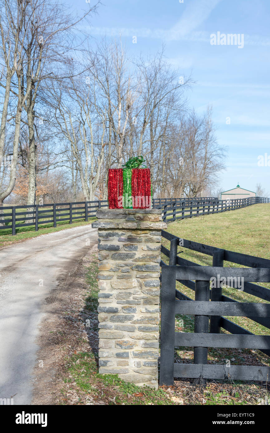 Christmas present decoration on a stone gate post at the entrance to a ...