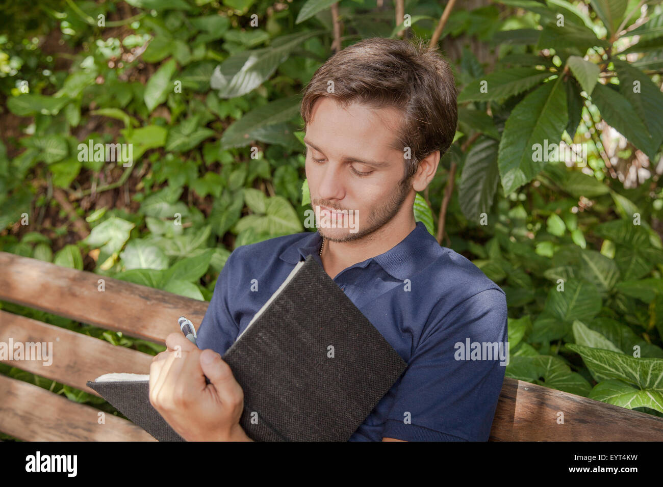 Man writing in a journal Stock Photo - Alamy