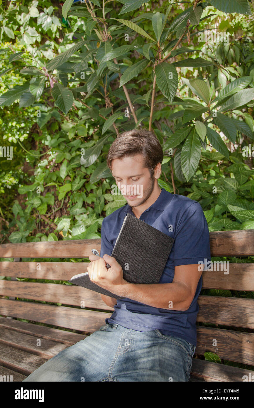 Man writing in a journal Stock Photo - Alamy
