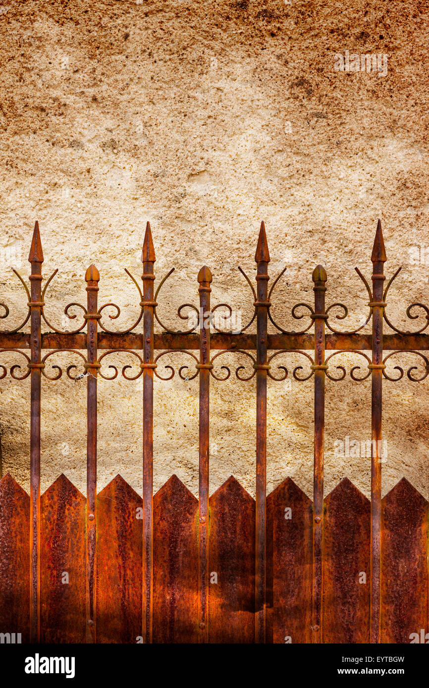 Rusty iron gate in front of stone wall Stock Photo - Alamy