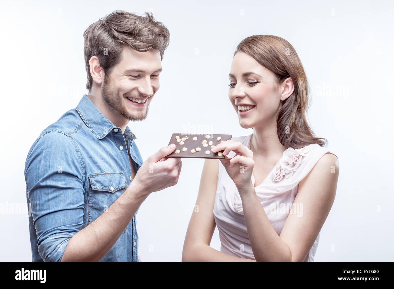 Young couple with a bar of chocolate with nuts Stock Photo - Alamy