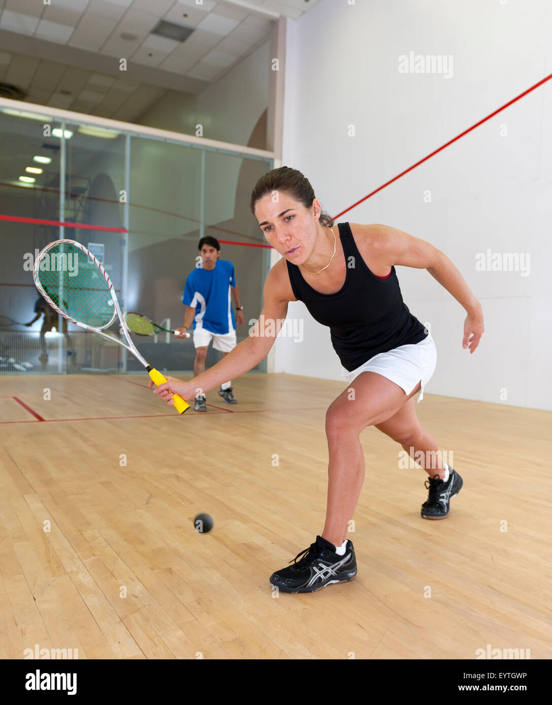 Woman squash player hitting a forehand swing Stock Photo - Alamy